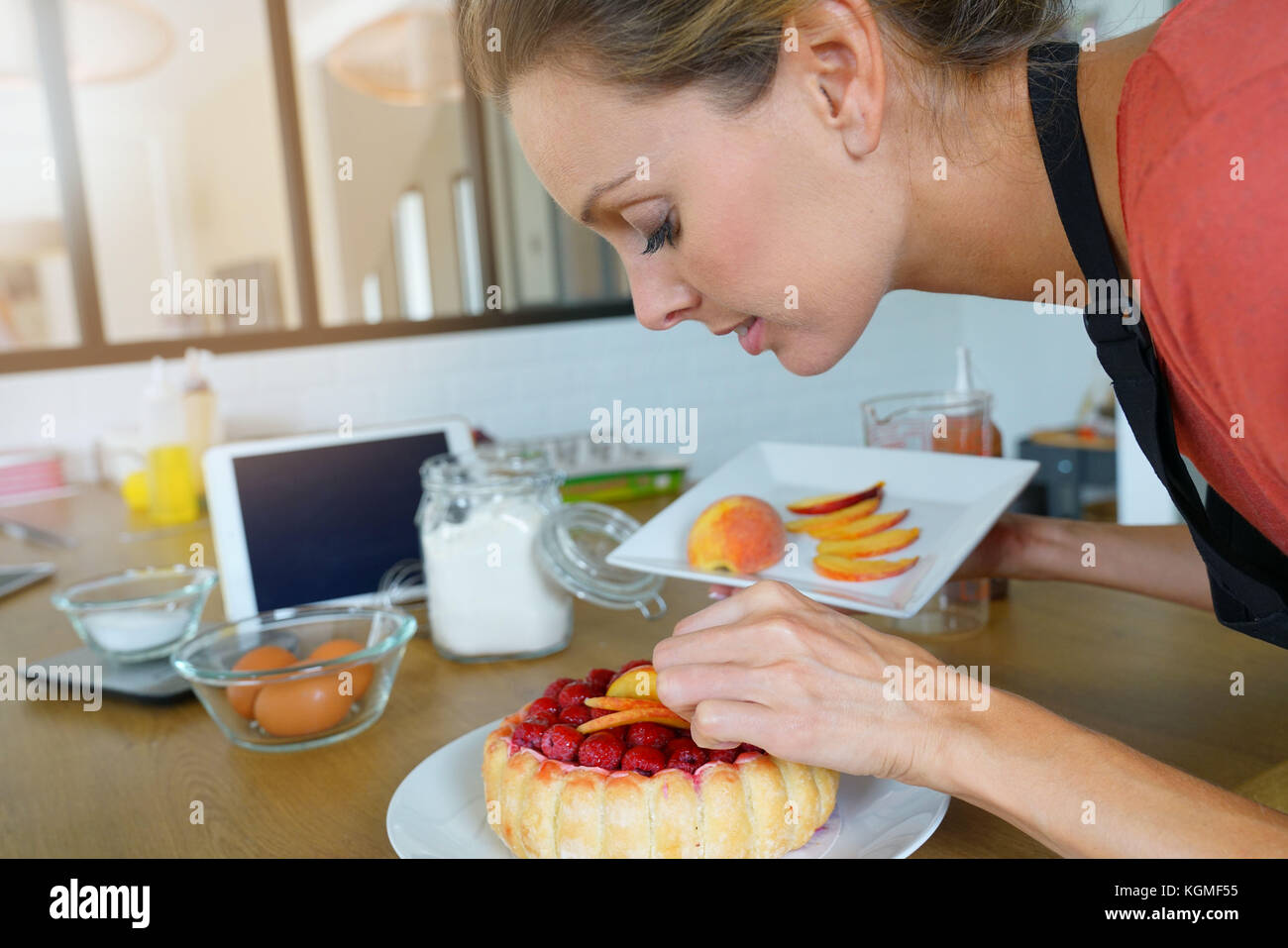 Young woman in modern kitchen baking raspberry cake Stock Photo - Alamy
