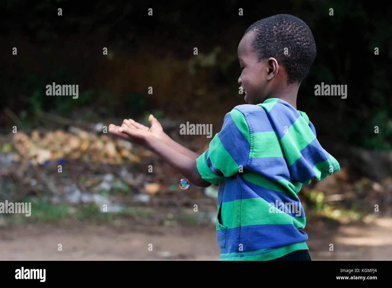 little boy wants to catch the bubbles blown by his mother Stock Photo ...