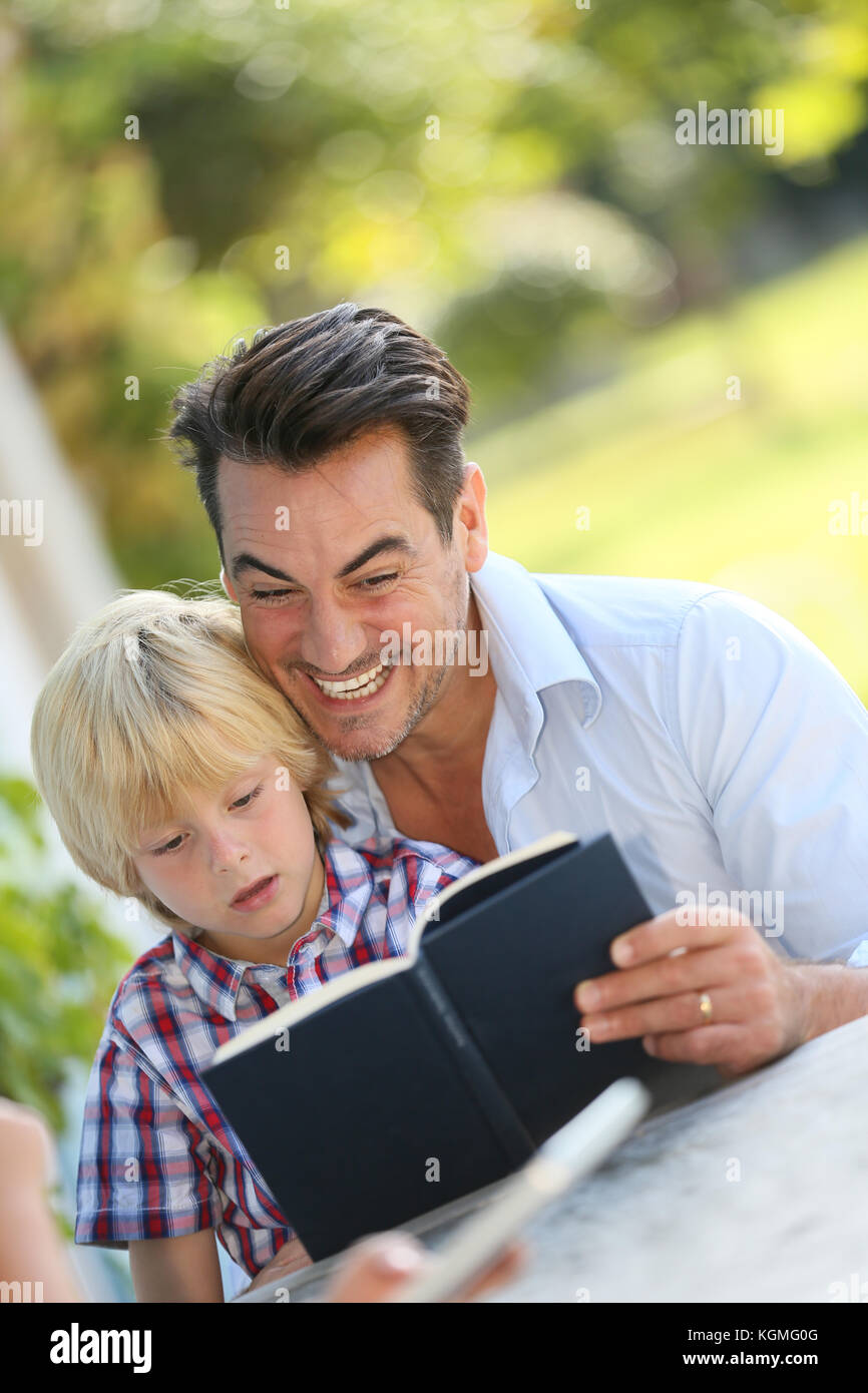 Daddy with kid reading book Stock Photo - Alamy