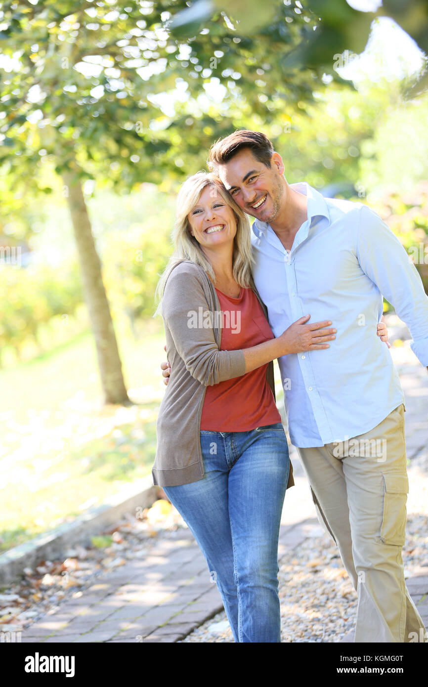 Couple walking hand in hand in park Stock Photo - Alamy