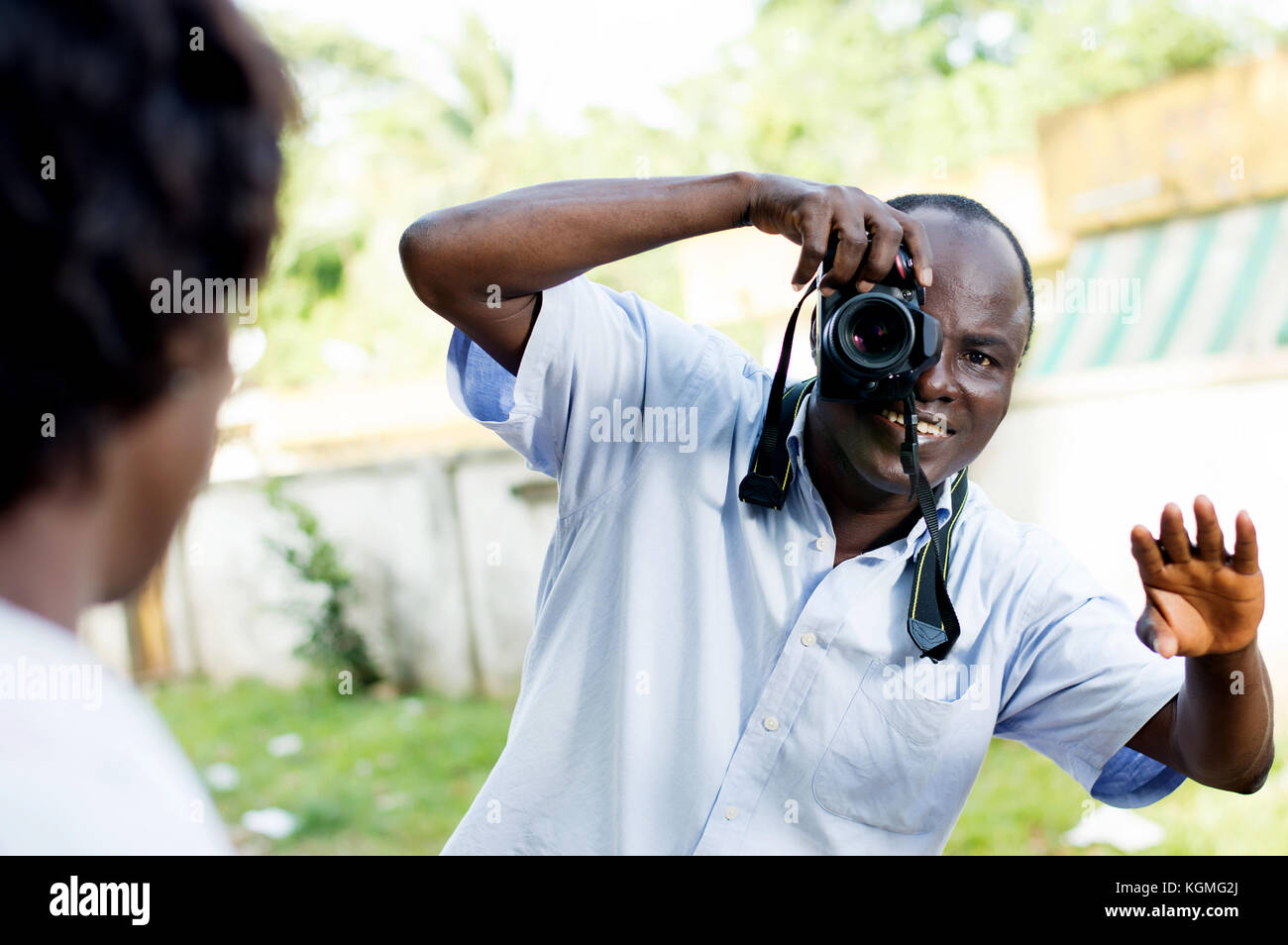 smiling young photographer taking a pose to his model and asking her ...