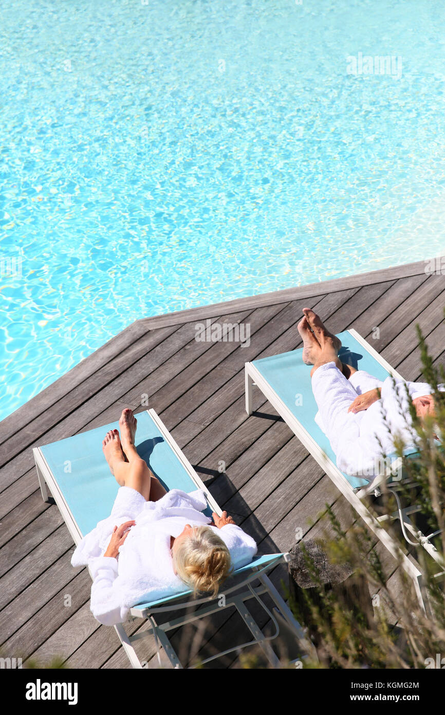 Senior couple relaxing by swimming pool in spa hotel Stock Photo - Alamy