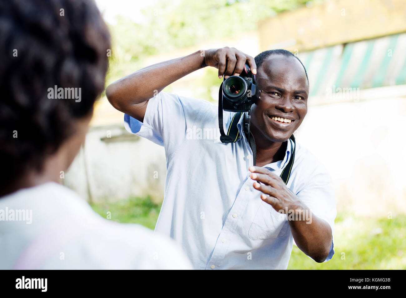 smiling young photographer taking a pose to his model and asking her ...
