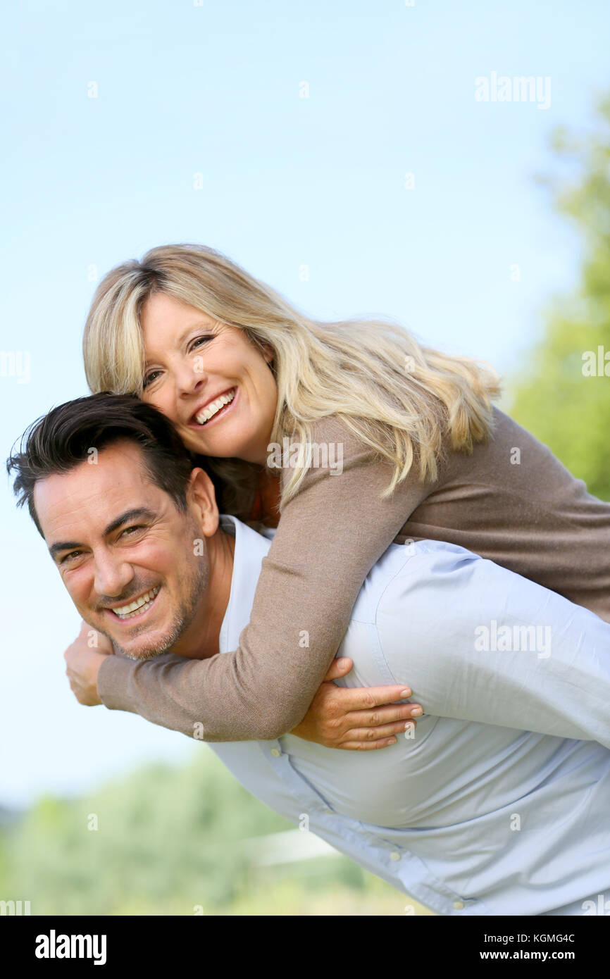 Mature man giving piggyback ride to woman hi-res stock photography and ...