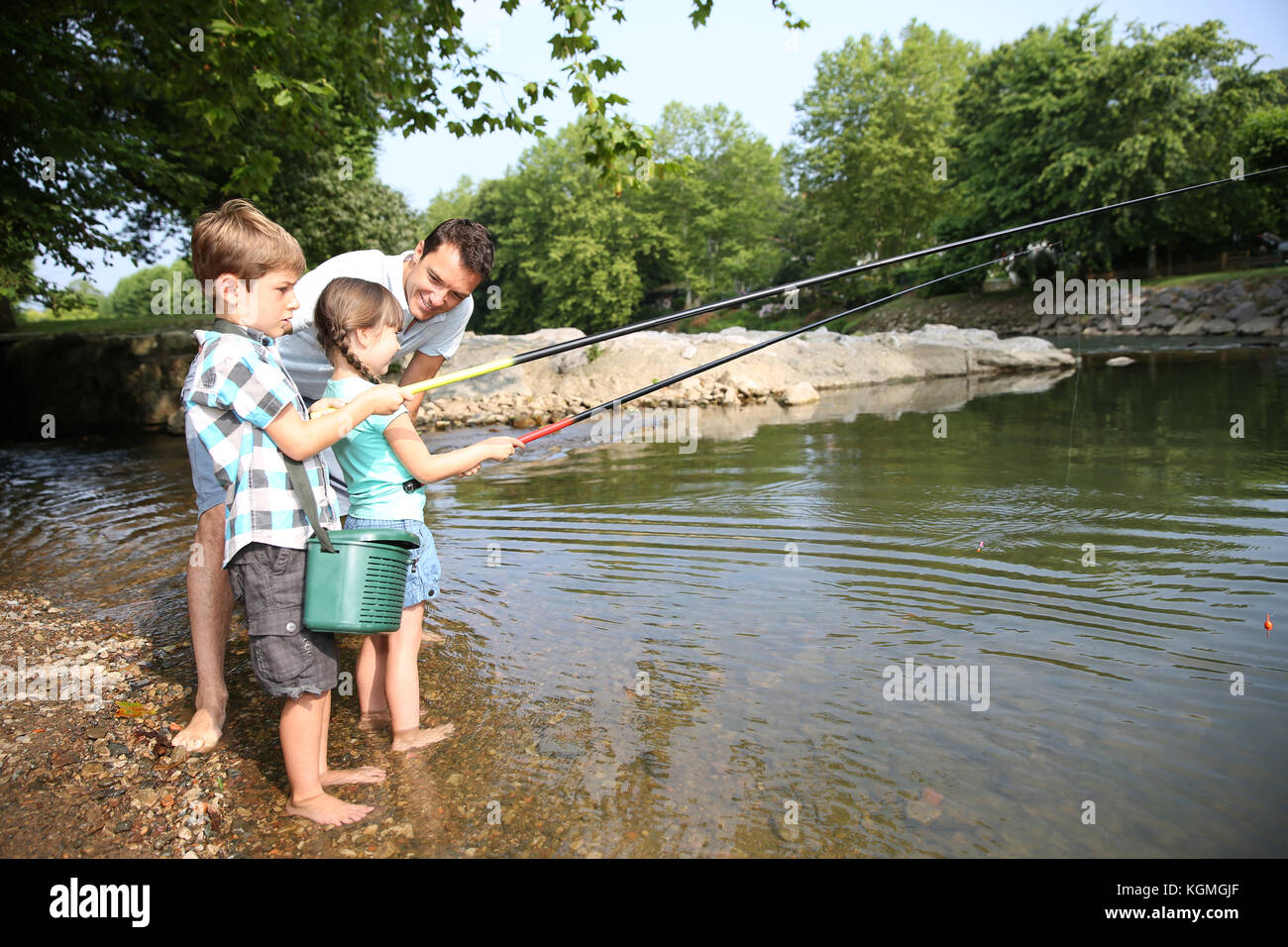 Man teaching kids how to fish in river hi-res stock photography and ...