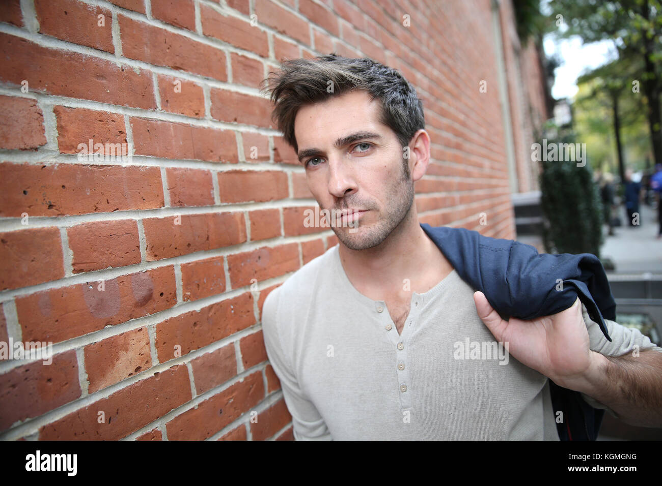 Man leaning on wall in the street Stock Photo - Alamy