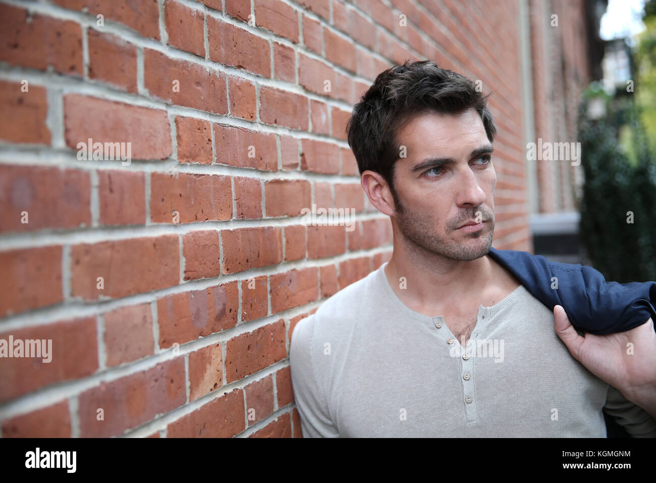 Man leaning on wall in the street Stock Photo - Alamy