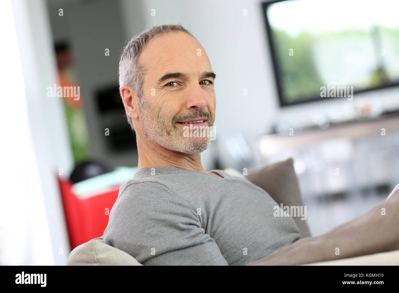 Senior man relaxing in sofa at home Stock Photo - Alamy