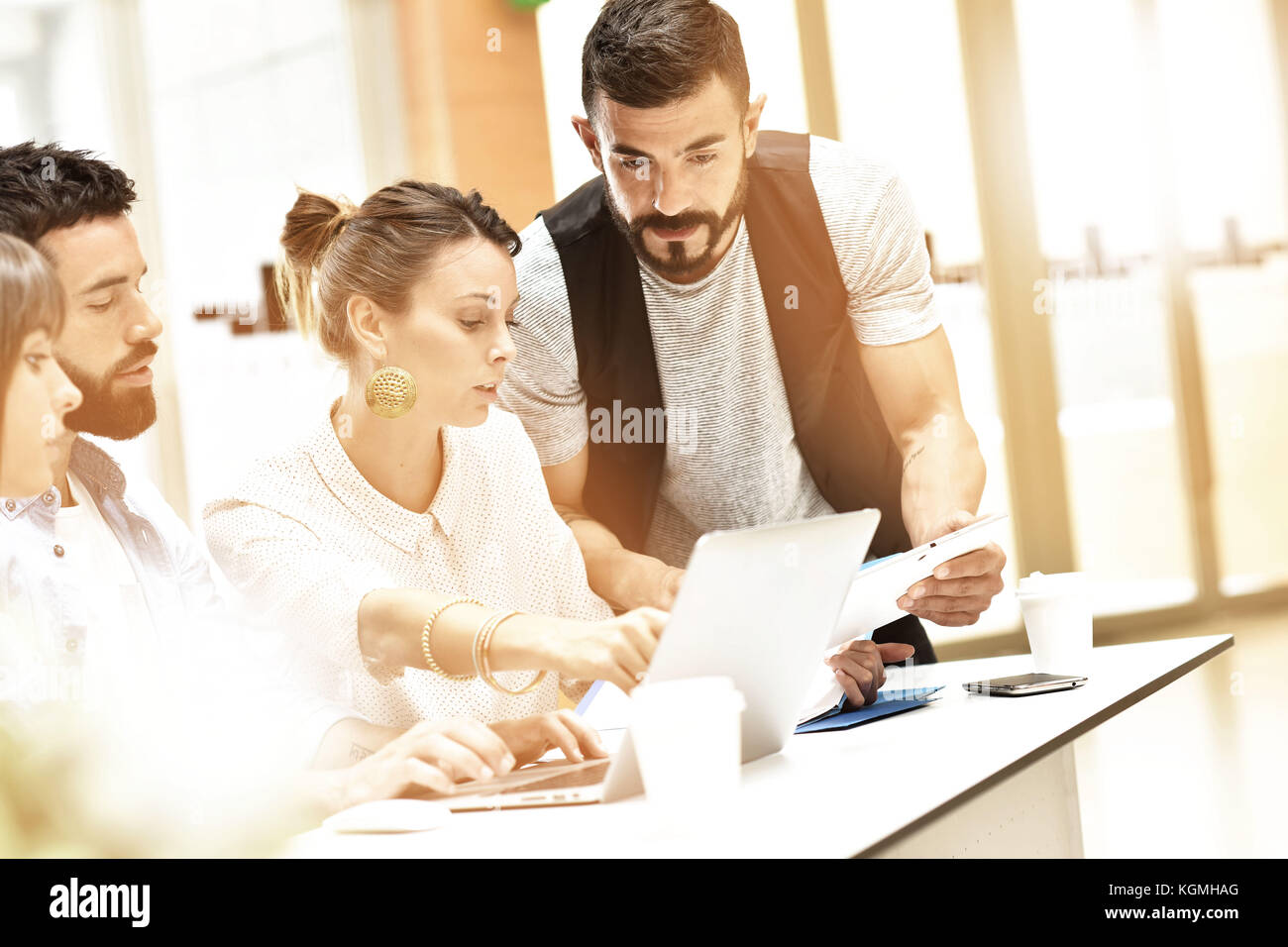 Design team meeting and working on laptop Stock Photo - Alamy