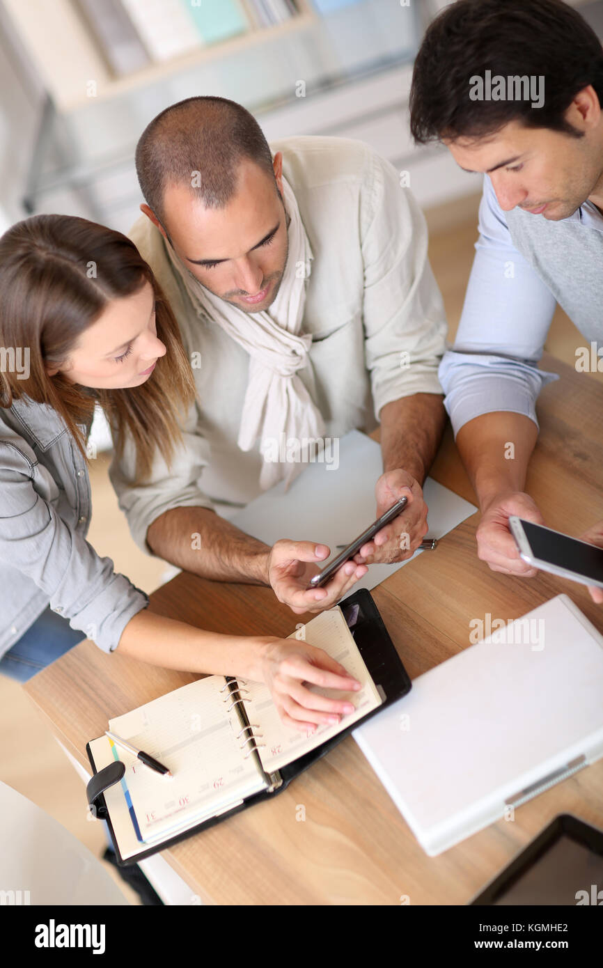 Business people using smartphone in meeting Stock Photo - Alamy
