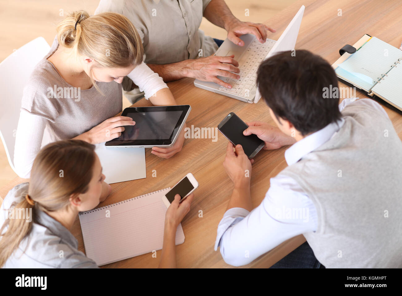 Group of business people using electronic devices at work Stock Photo ...