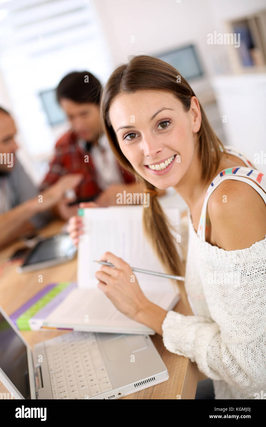 Girl in class studying with laptop and school book Stock Photo - Alamy
