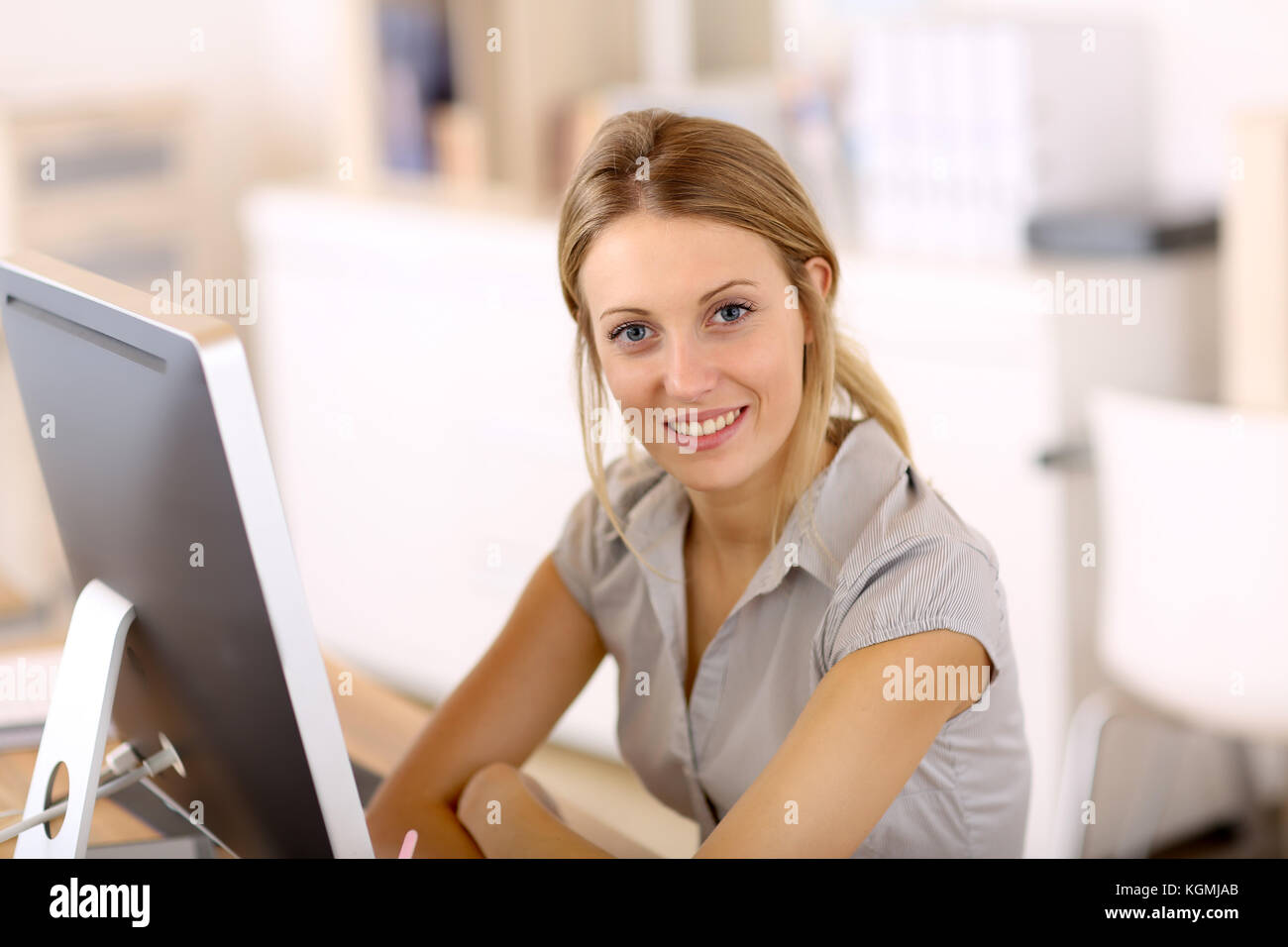 Beautiful blond girl working in office on desktop Stock Photo - Alamy