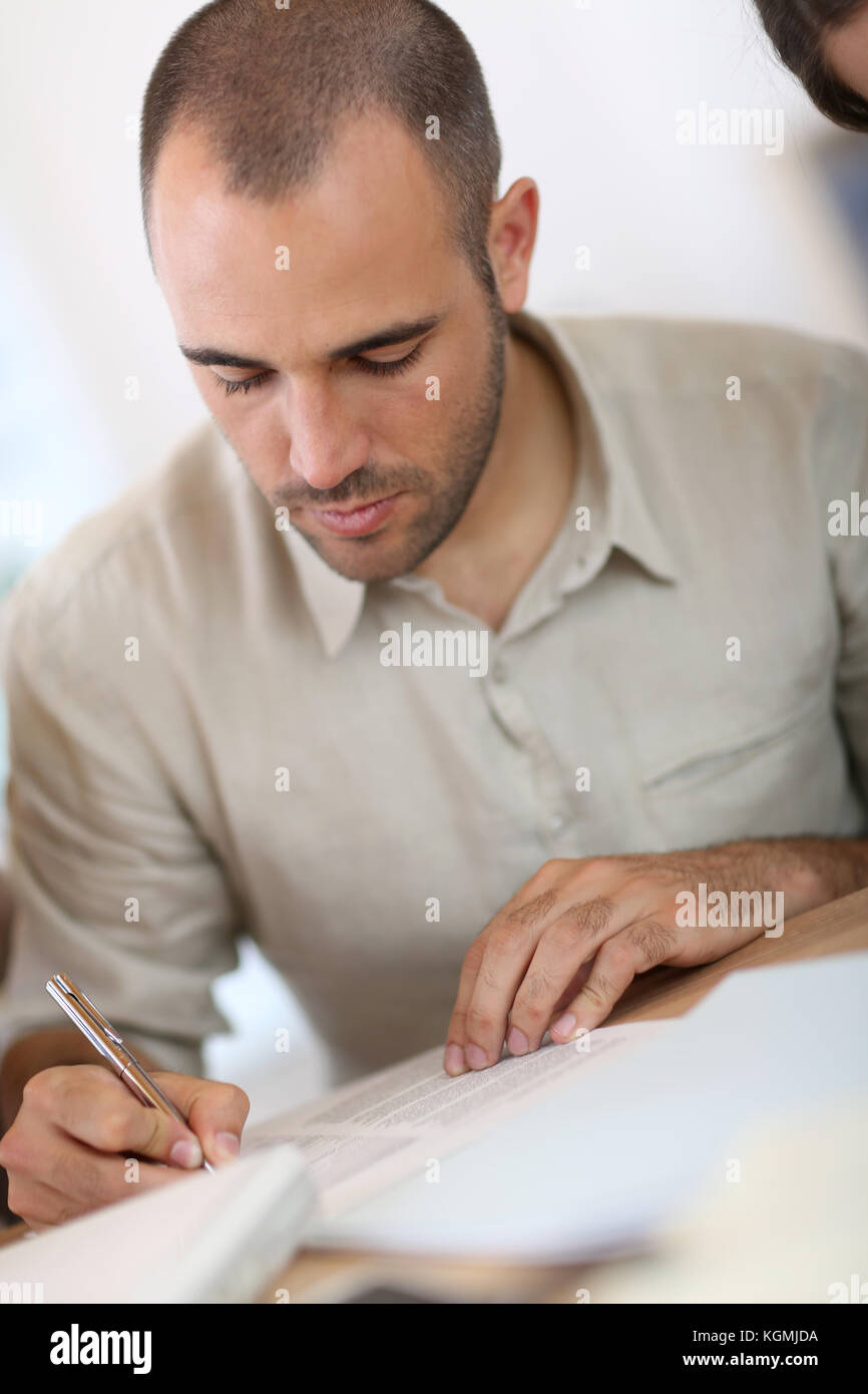 Portrait of young man filling in application form Stock Photo - Alamy