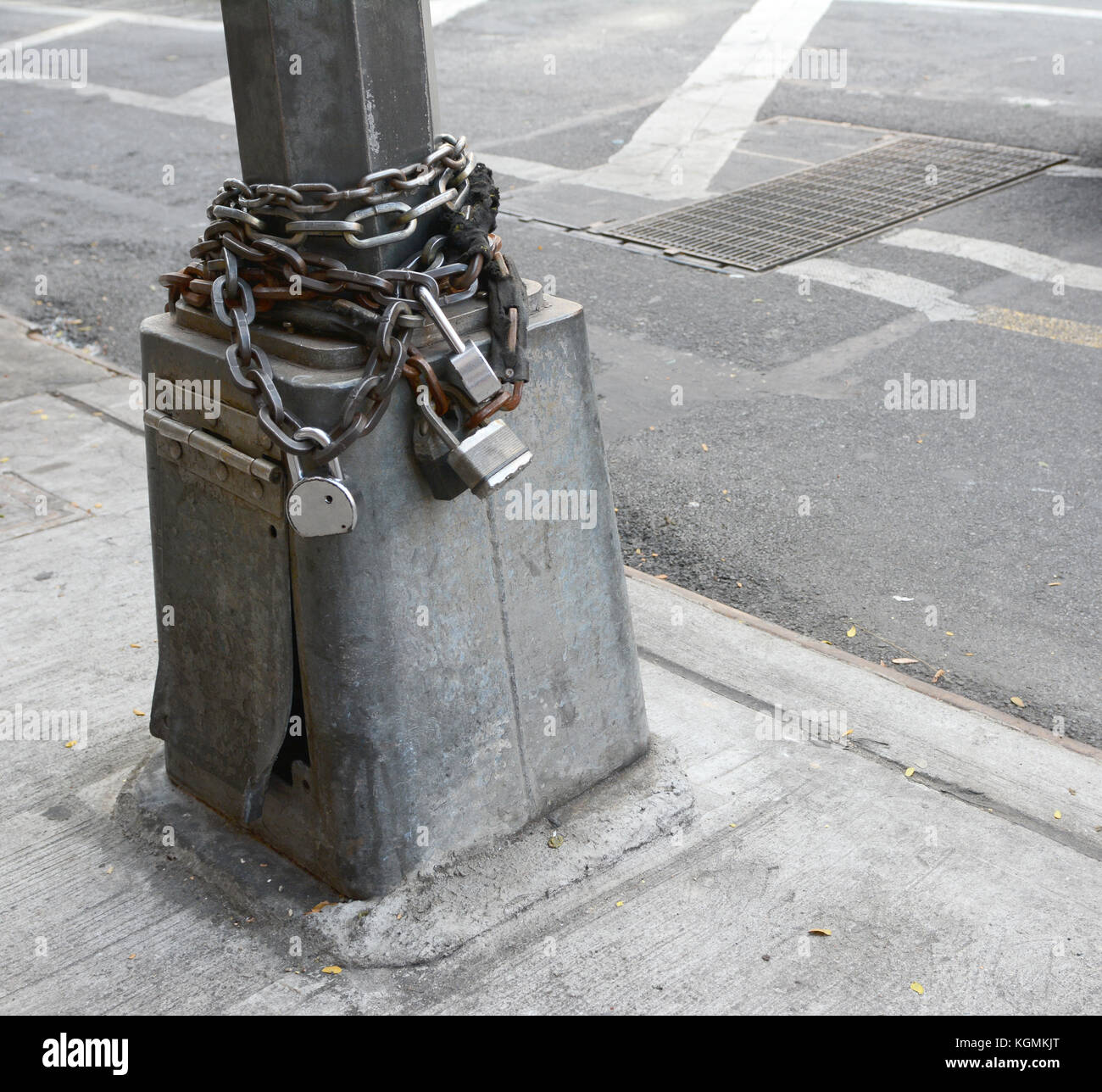 Heavy metal chains and padlocks wound around the base of a streetlight ...