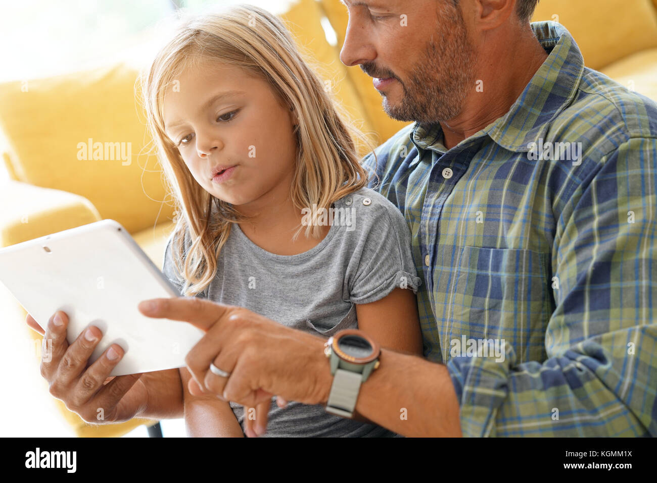 Daddy with little girl connected on digital tablet Stock Photo - Alamy
