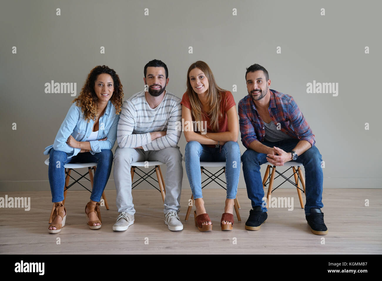 Group of young people sitting on chairs, isolated Stock Photo - Alamy