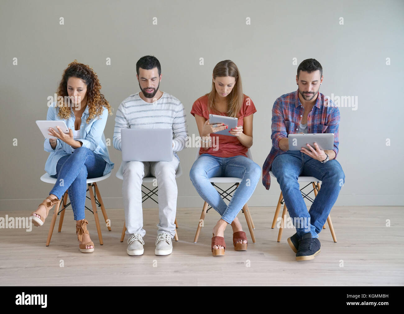 Young people connected on internet in waiting room Stock Photo - Alamy