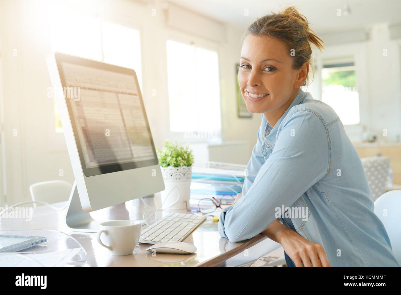Beautiful young woman in office working on desktop computer Stock Photo ...