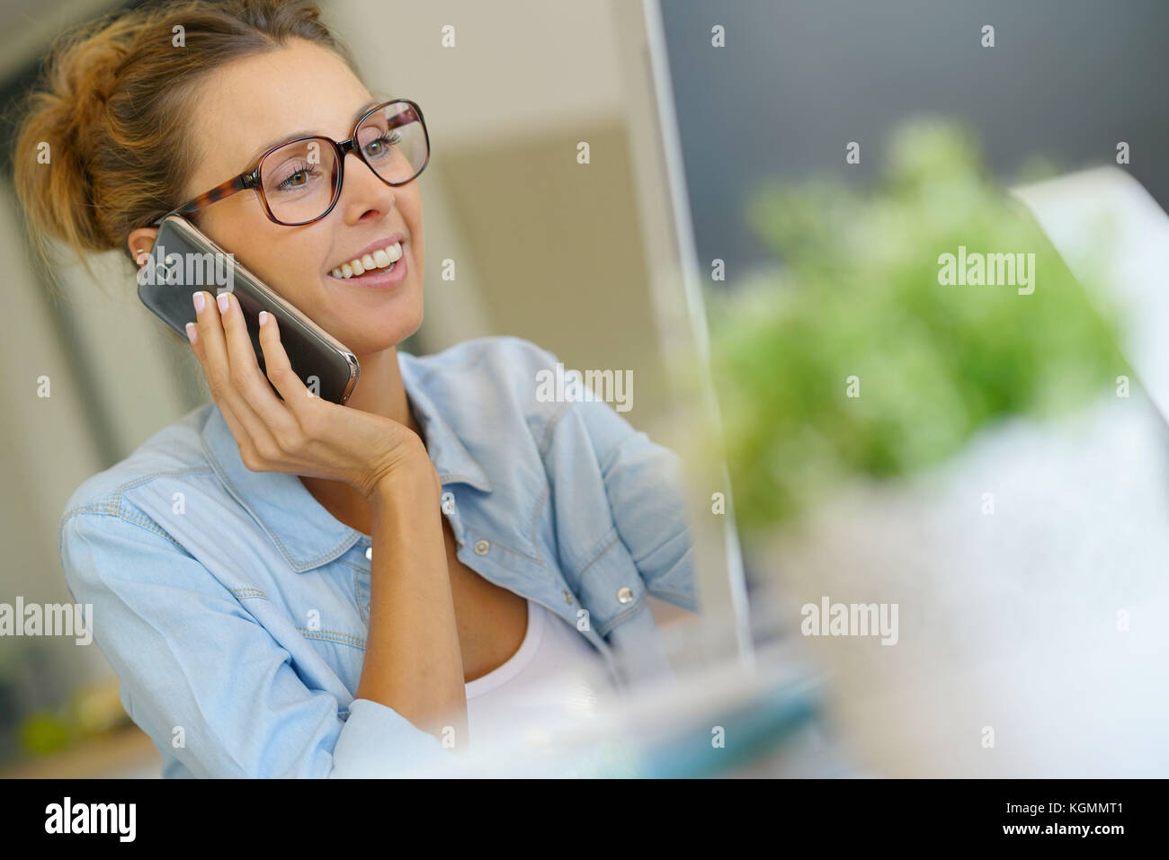 Office worker talking on phone in front of desktop Stock Photo - Alamy