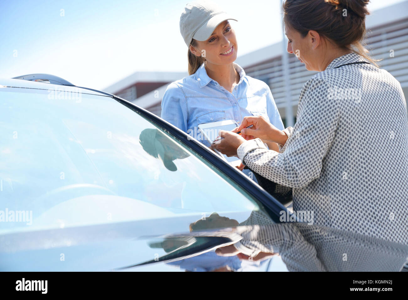 Woman in parking lot renting car from rental company Stock Photo - Alamy
