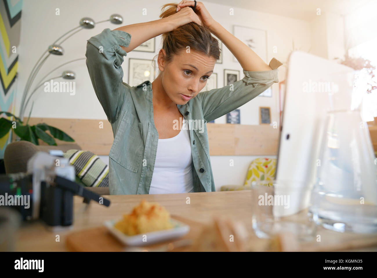 Young woman putting her hair up Stock Photo - Alamy