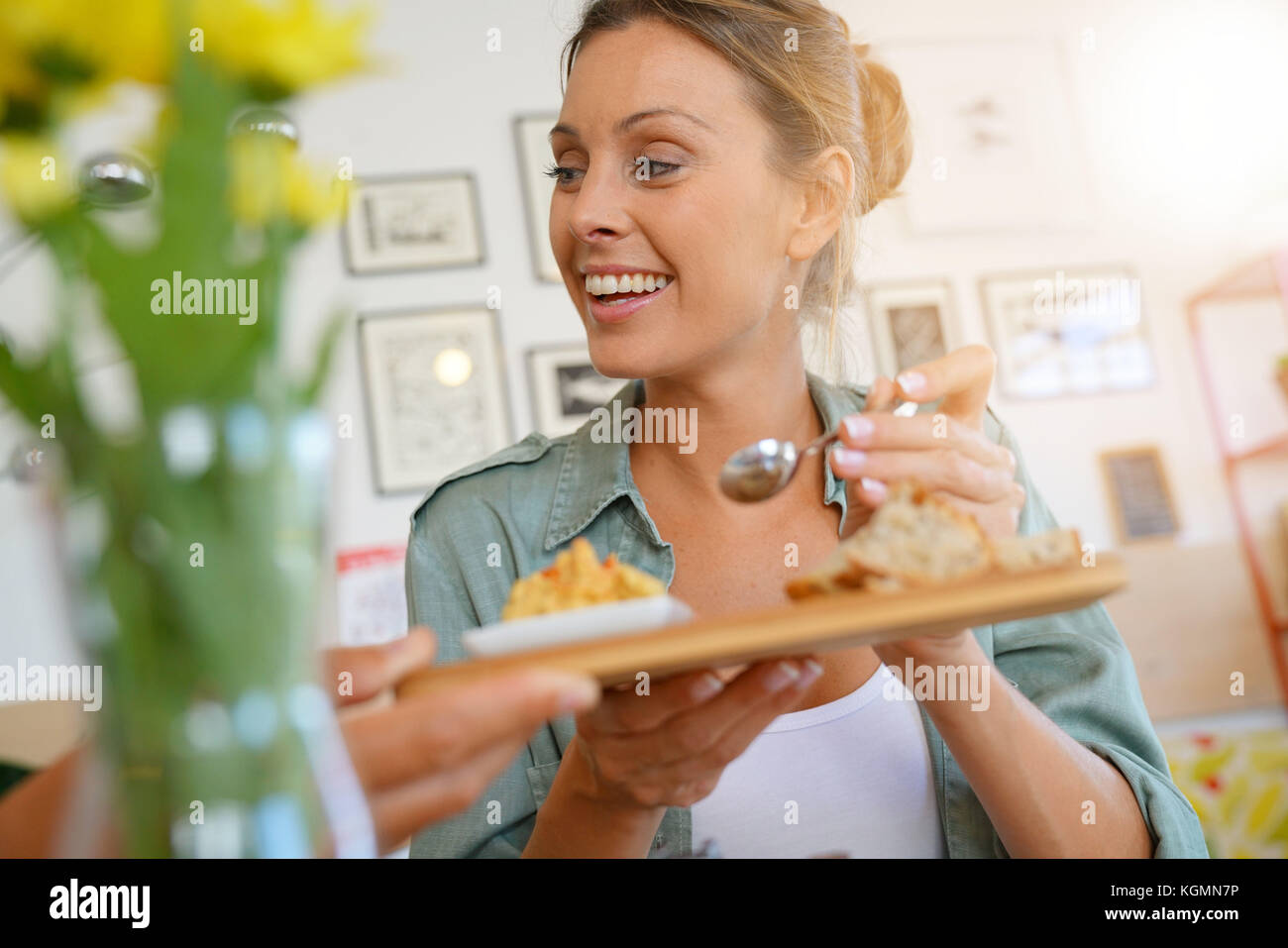 Young woman in restaurant eating fingerfood Stock Photo - Alamy