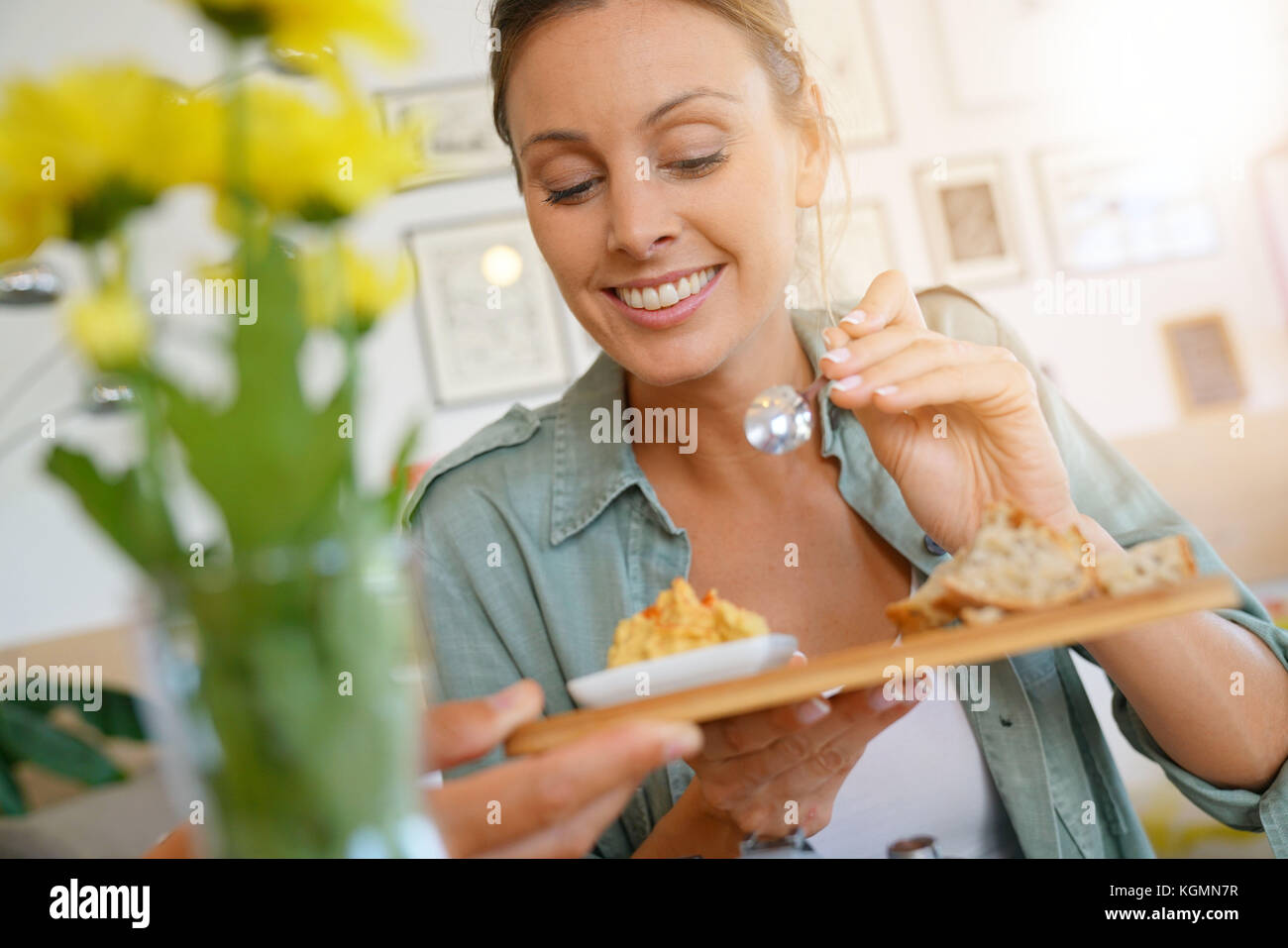 Young woman in restaurant eating fingerfood Stock Photo - Alamy