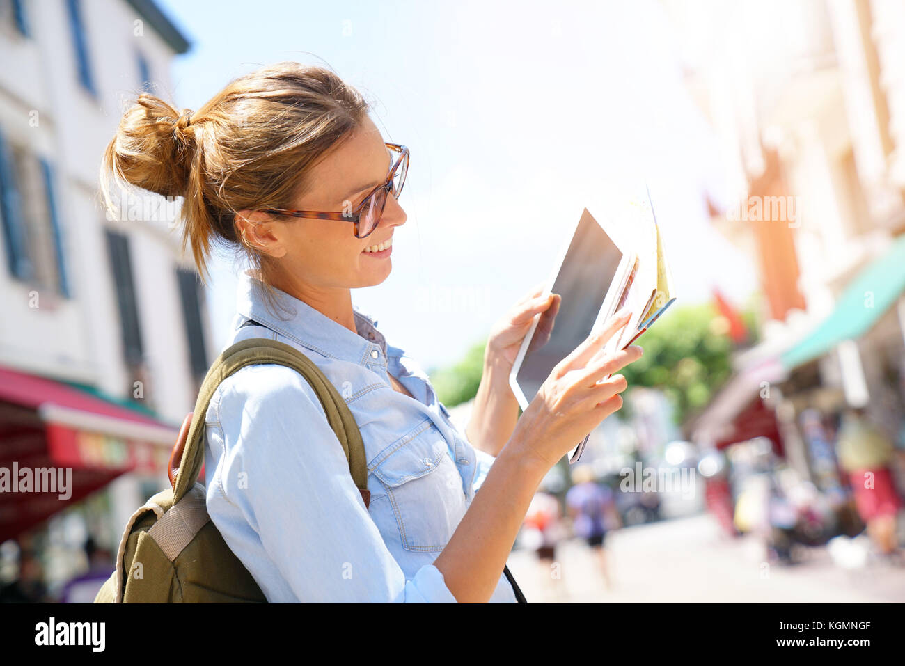 Happy tourist girl reading map and using tablet in the street Stock ...