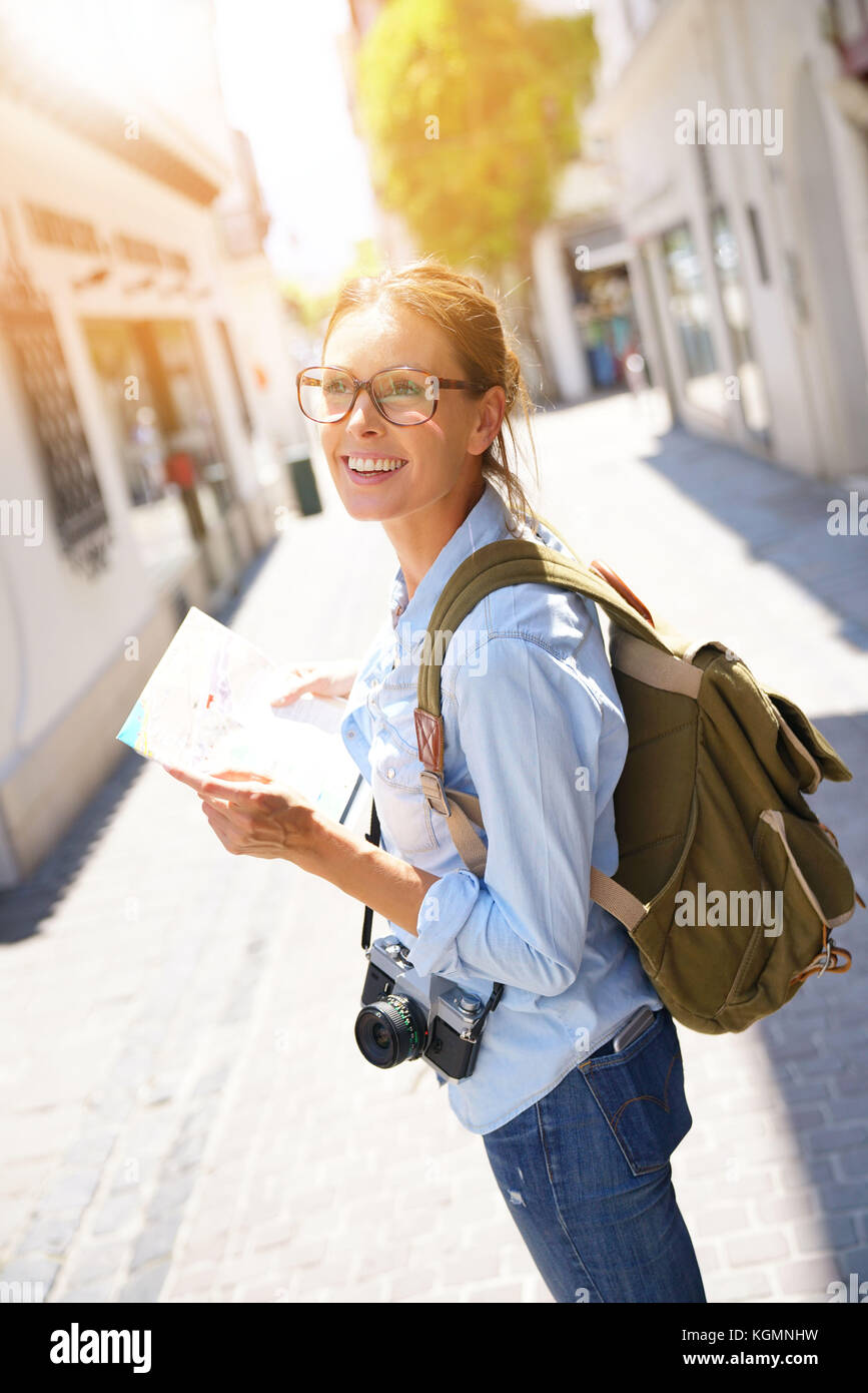 Happy tourist girl reading map and using tablet in the street Stock ...