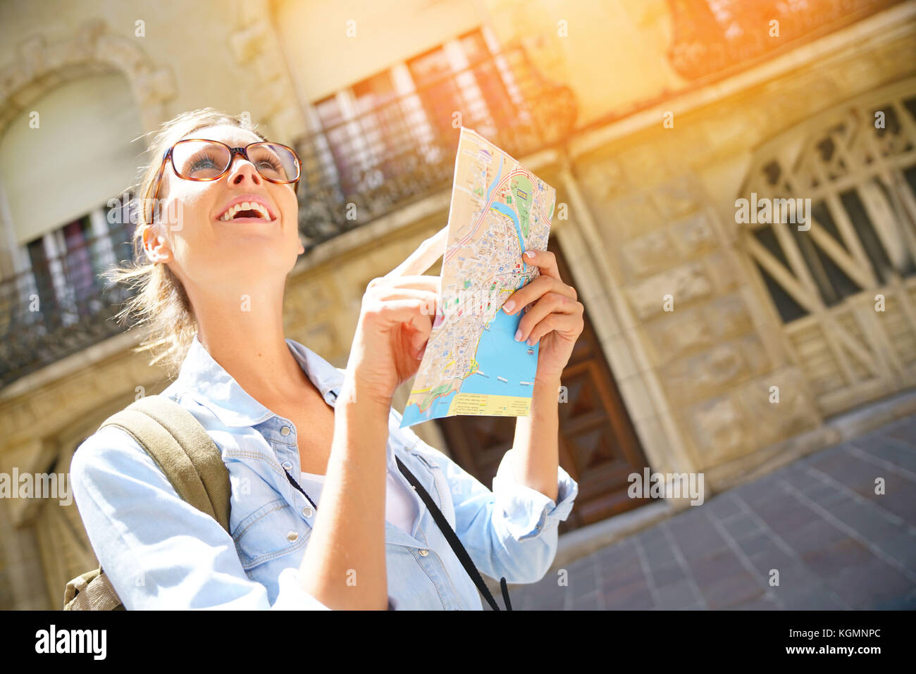 Tourist with backpack reading city map Stock Photo - Alamy