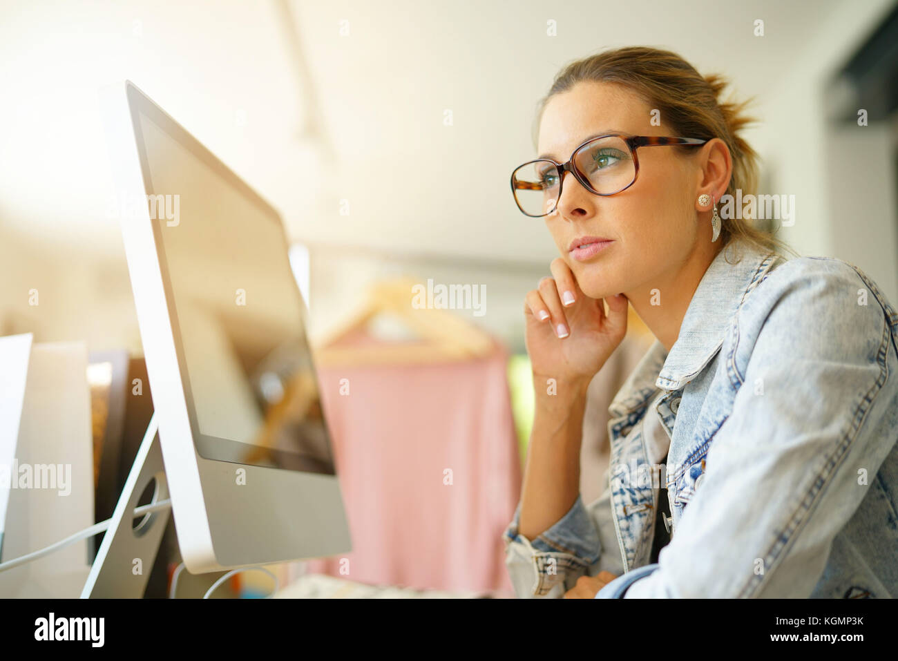 Fashion designer working on computer in workshop Stock Photo - Alamy