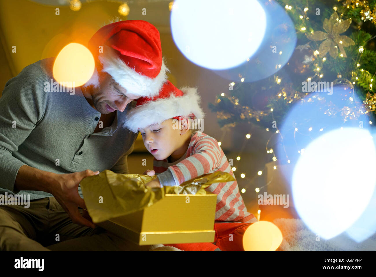 Daddy and little boy opening christmas gift Stock Photo - Alamy