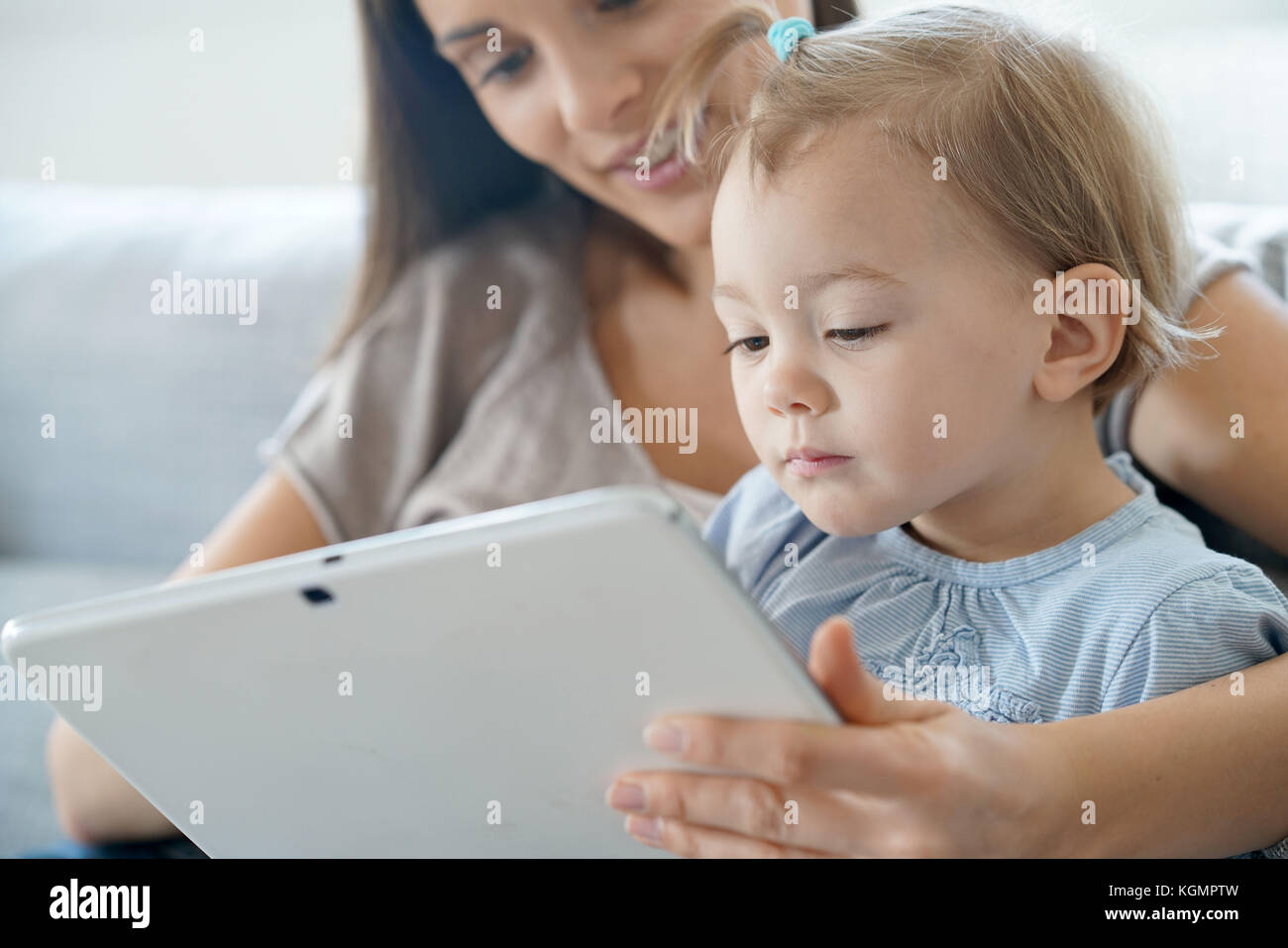 Mother and daugther using digital tablet at home Stock Photo - Alamy