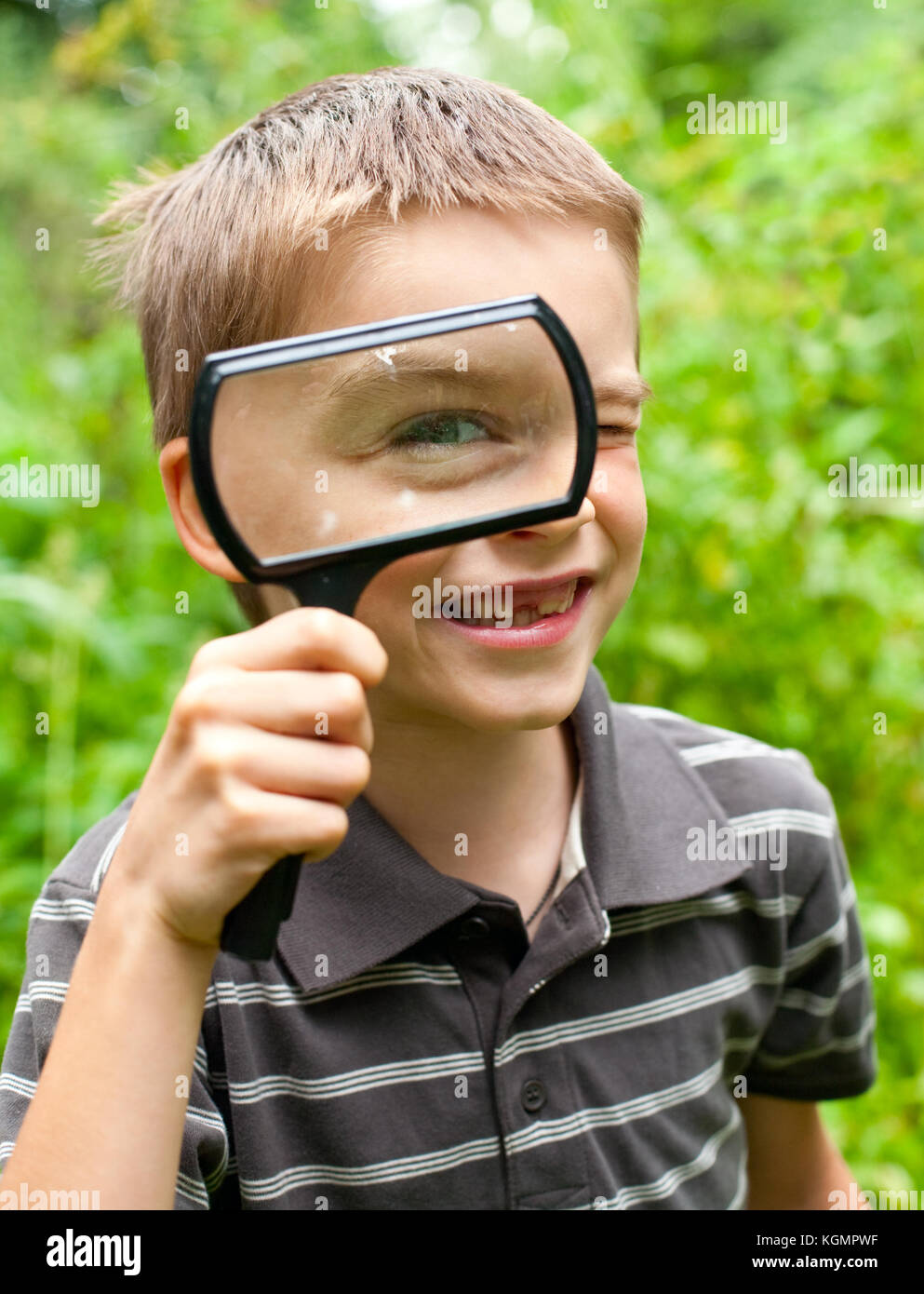 Cheerful boy looking through hand magnifier, shallow DOF Stock Photo ...