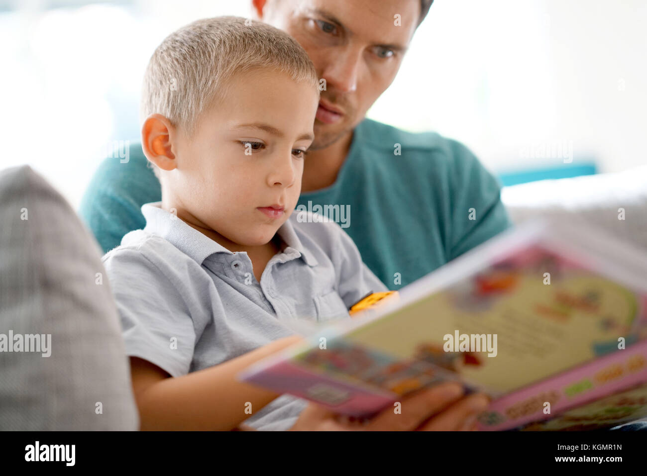 Father and son reading story book together Stock Photo - Alamy