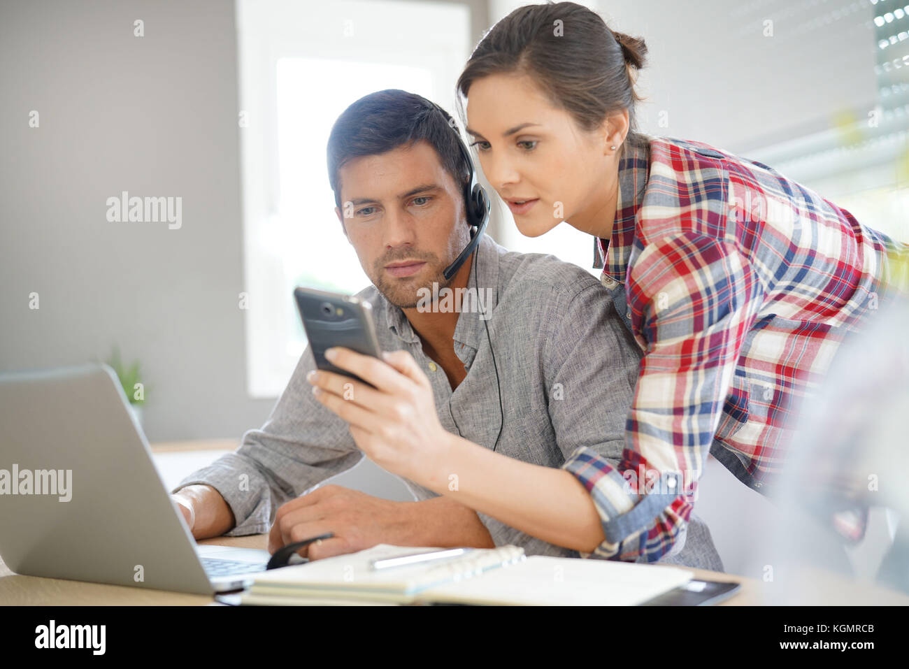 Workteam in office working together on laptop Stock Photo - Alamy