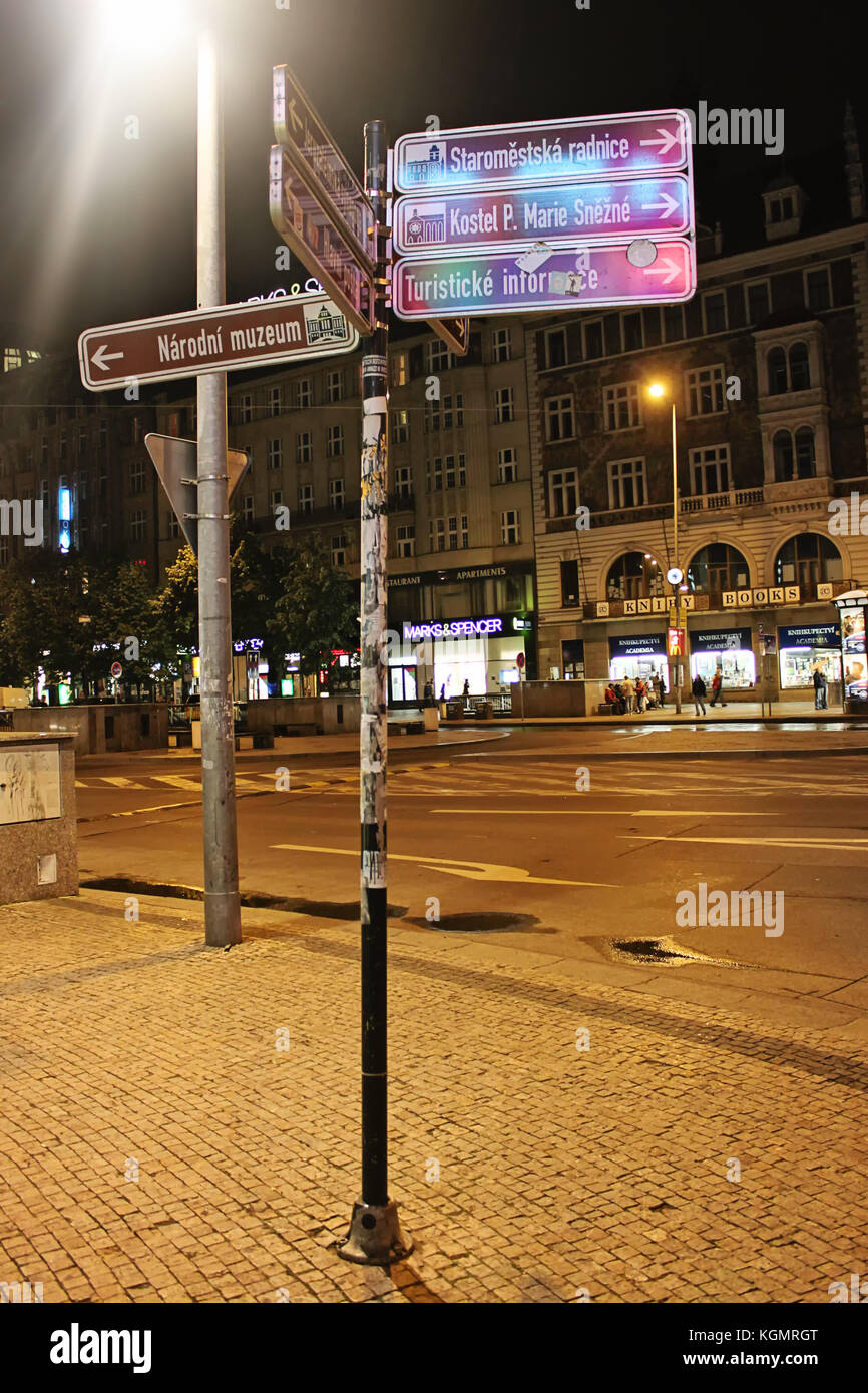 Street sign illuminated by street lamp indicating the direction in ...