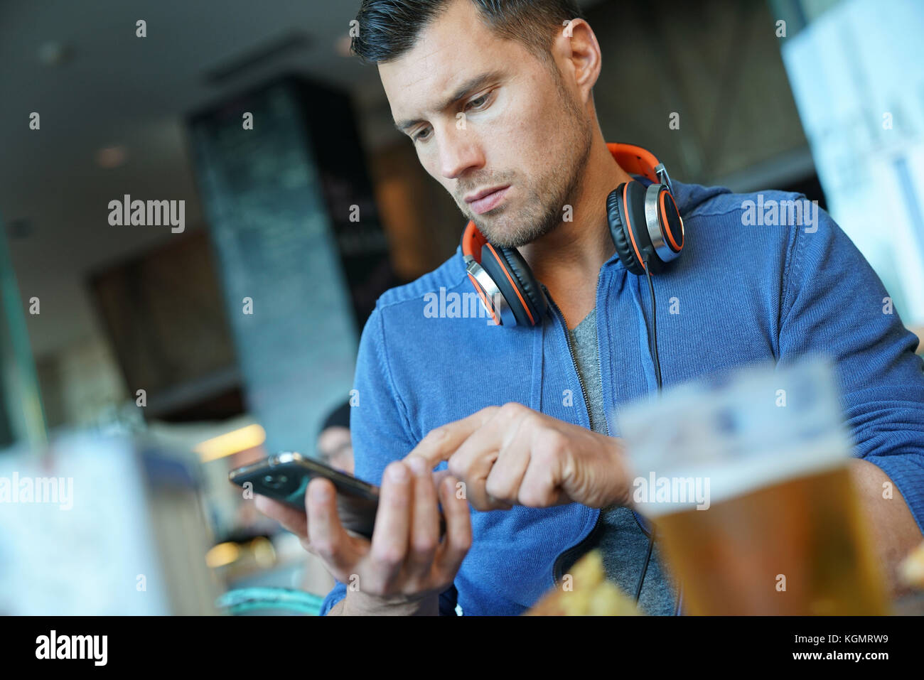 Man relaxing in restaurant, using smartphone Stock Photo - Alamy