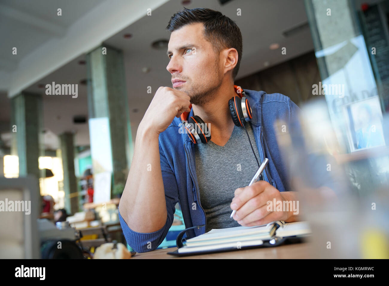 Man sitting in restaurant writing notes on agenda Stock Photo - Alamy