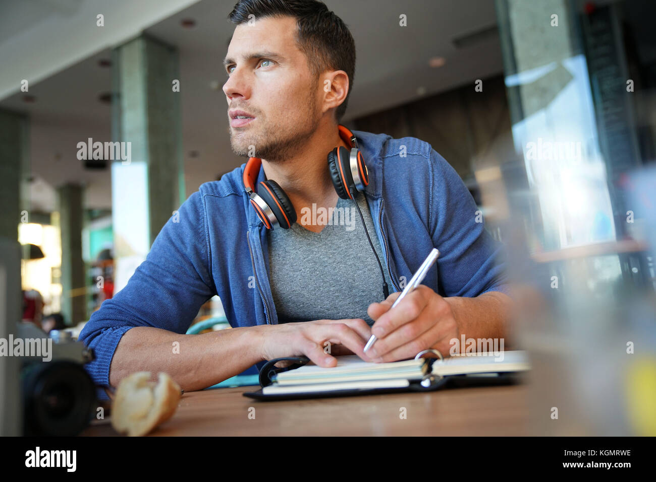 Man sitting in restaurant writing notes on agenda Stock Photo - Alamy