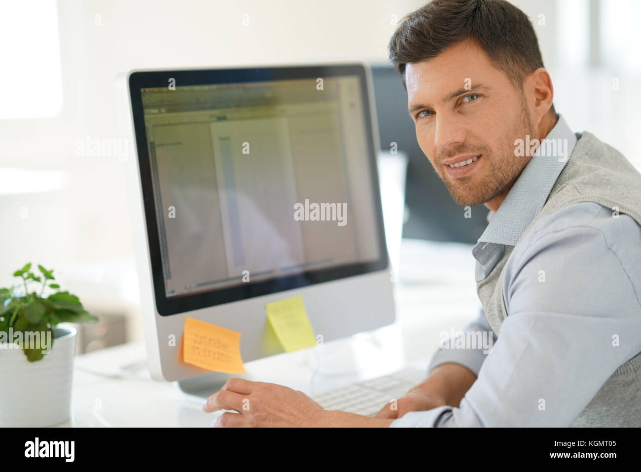 Handsome businessman working on desktop computer in office Stock Photo ...