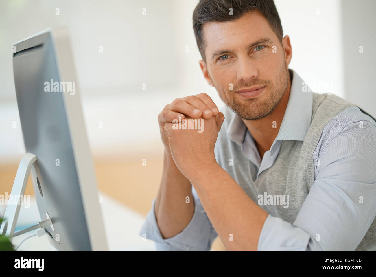 Handsome businessman working on desktop computer in office Stock Photo ...