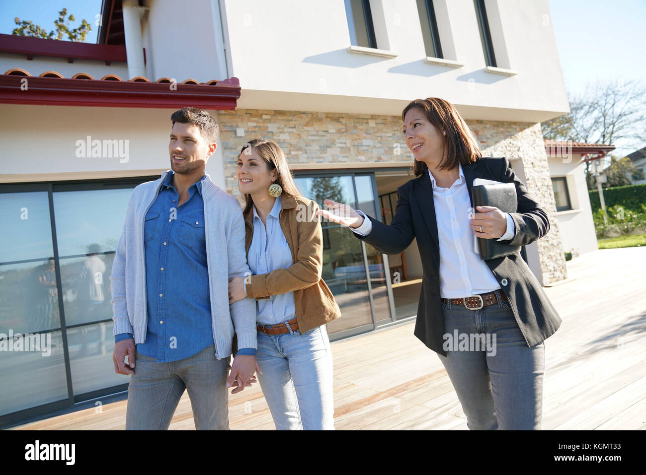 Couple with real-estate agent visiting house for sale Stock Photo - Alamy