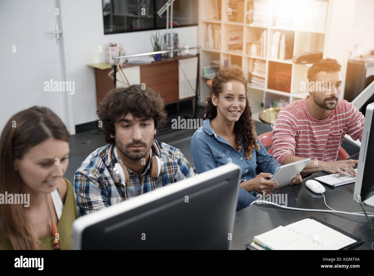 Start-up people working on desktop in co-working space Stock Photo - Alamy