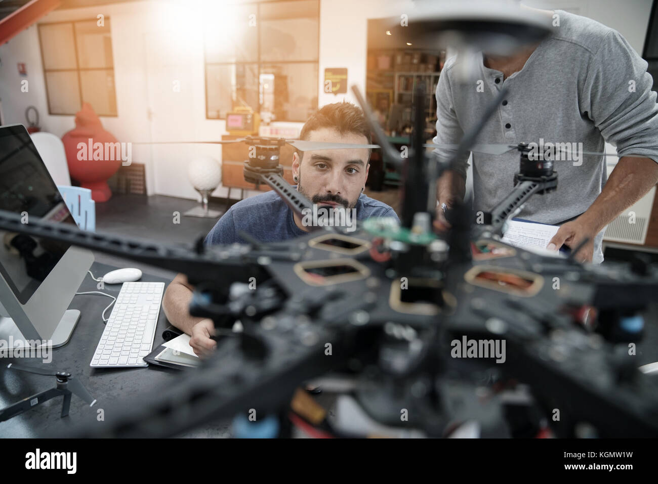 Engineer and technician working together on drone in office Stock Photo ...