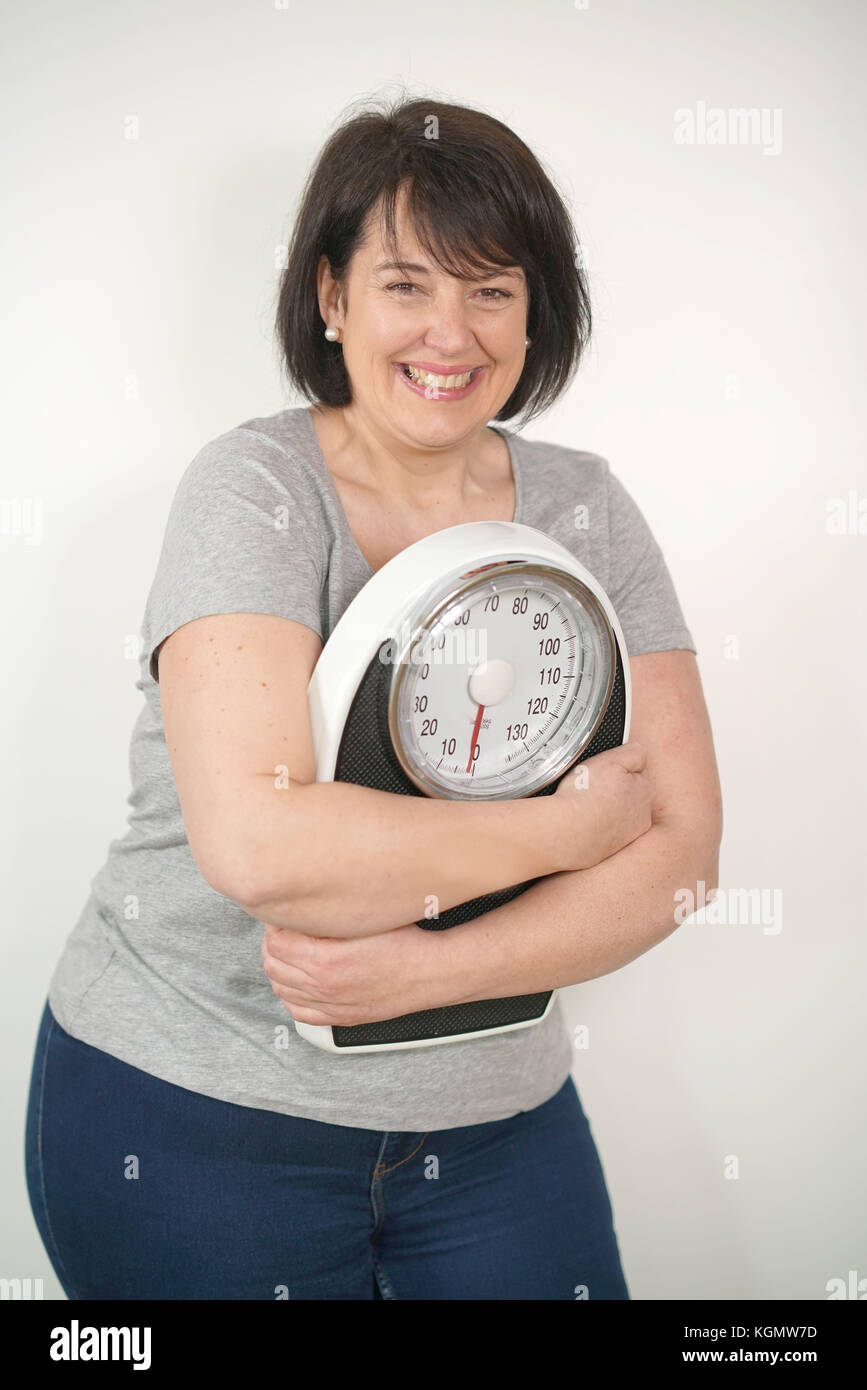 Overweight woman holding scale on white background Stock Photo - Alamy