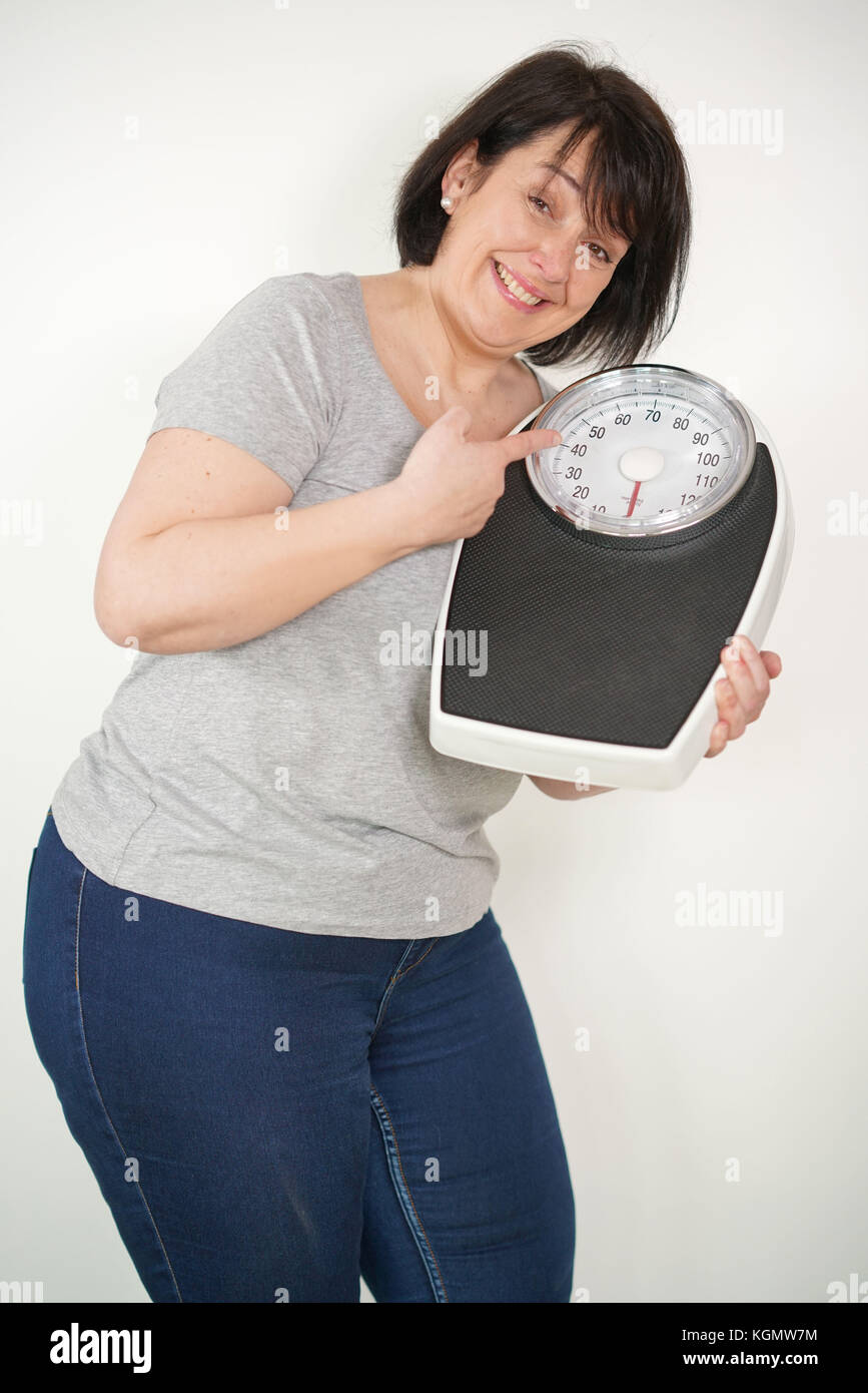 Overweight woman holding scale on white background Stock Photo - Alamy