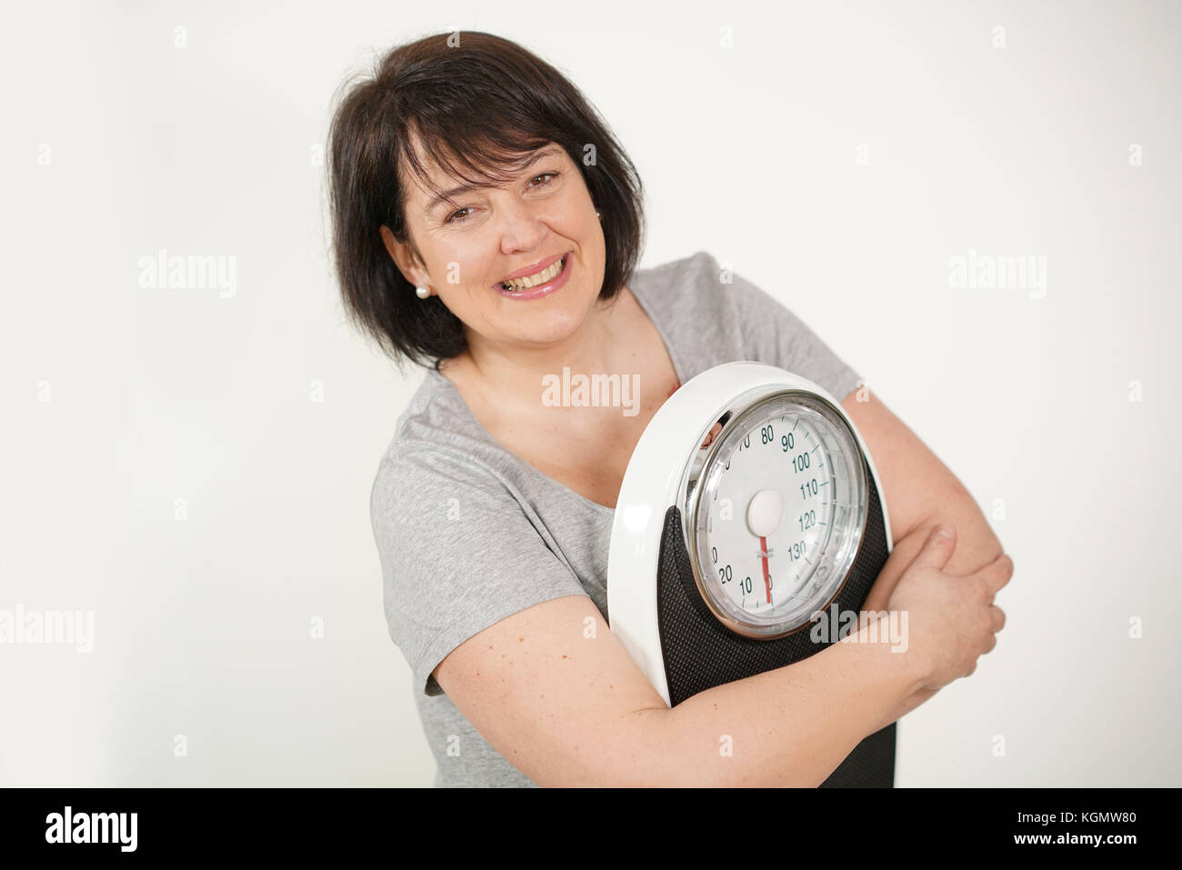 Overweight woman holding scale on white background Stock Photo - Alamy