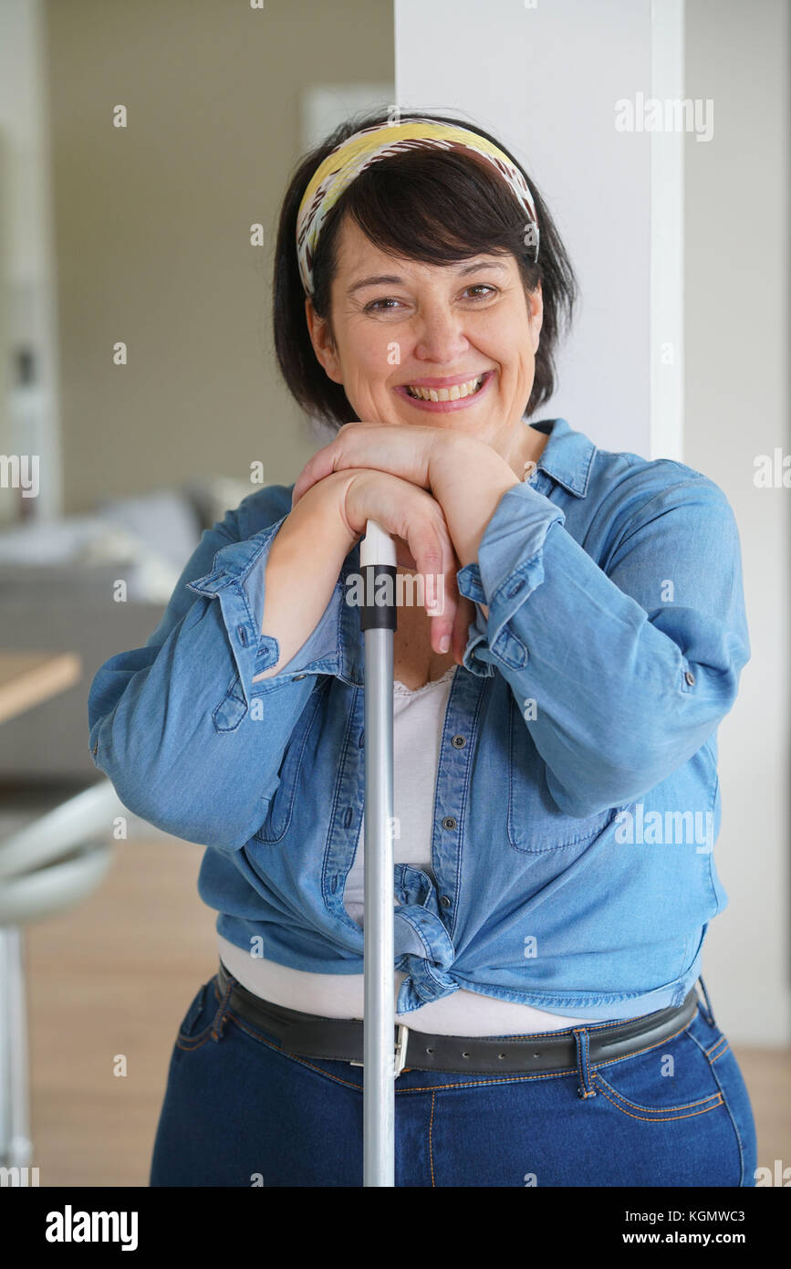 Cheerful overweigth woman having fun sweeping the floor Stock Photo - Alamy
